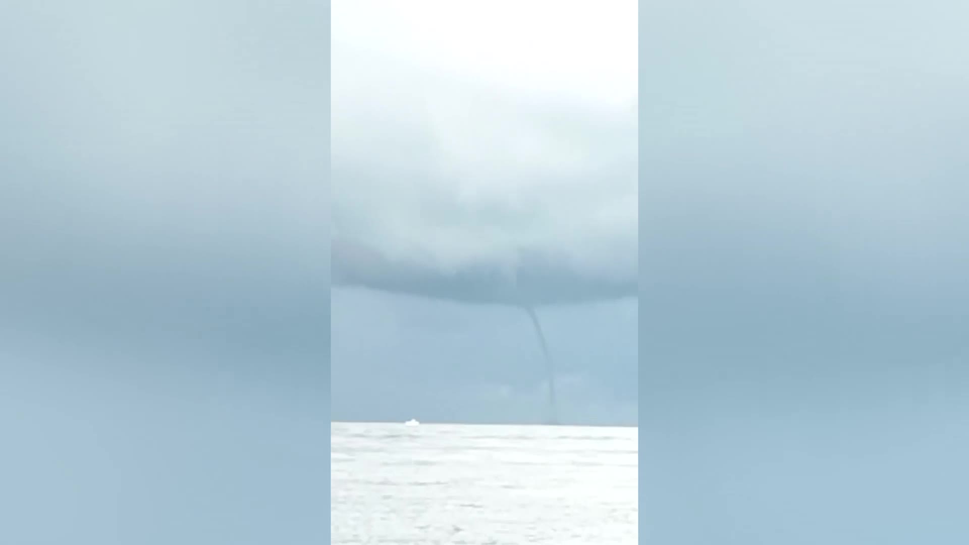 Waterspout tornado forms under thick cluster of storm clouds in ...