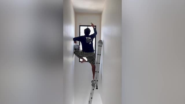 Gymnast-like painter stretches into awkward positions while decorating ...